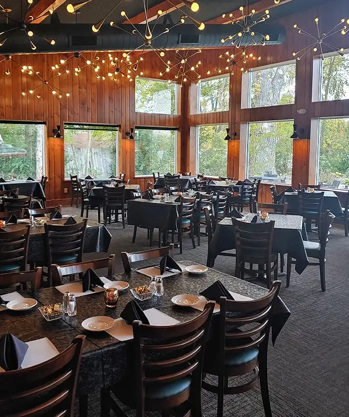 Starburst chandeliers dance above warm wood paneling, creating the perfect Wisconsin trifecta: cozy ambiance, nature views, and tables eagerly awaiting hungry patrons.