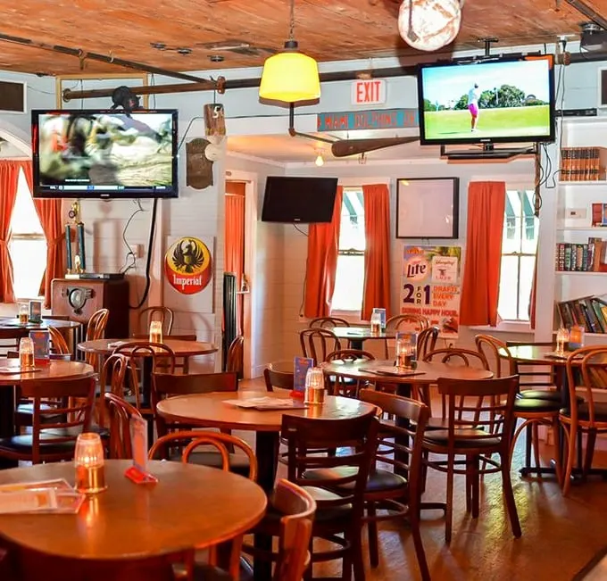 Inside Conchy Joe's, wooden tables and orange curtains create that perfect "I'm on vacation even though I live here" vibe that Floridians treasure.