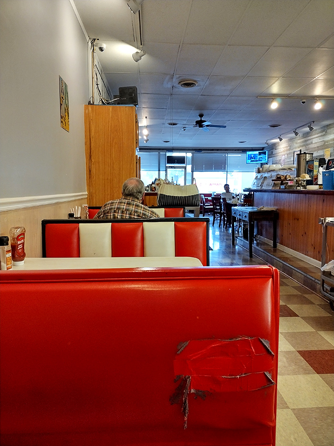 Red and white booths tell stories of countless meals shared. The checkerboard floor and well-worn seats aren't trendy design choices—they're badges of authentic diner honor.