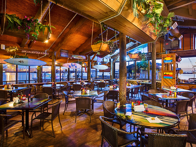 Wooden beams, hanging plants, and water views create the perfect backdrop for seafood feasting—no white tablecloths required.