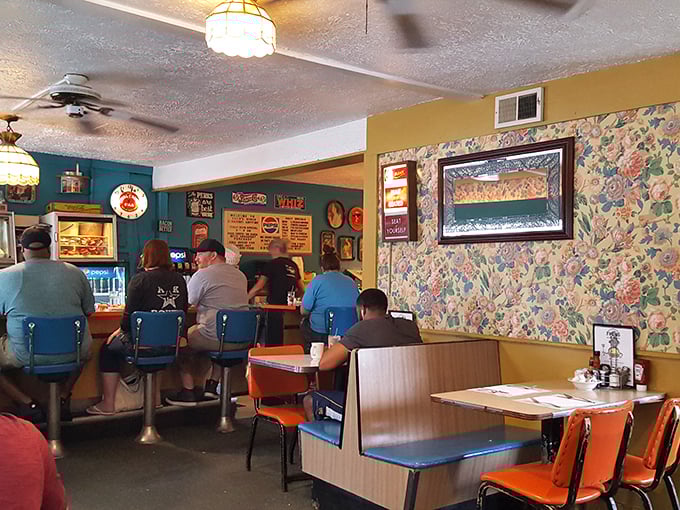 Blue swivel stools and floral wallpaper create the perfect time capsule where conversations flow as freely as the coffee.