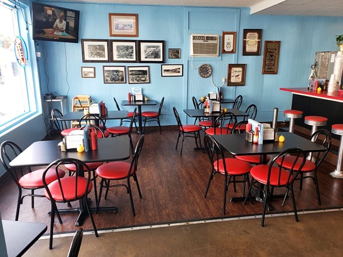 Blue walls adorned with local memories, red chairs that say "stay awhile"—this isn't just dining, it's a community living room with better food.