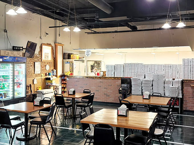 Simple wooden tables, practical chairs, and stacks of pizza boxes ready for action—this is a place that puts substance over style.