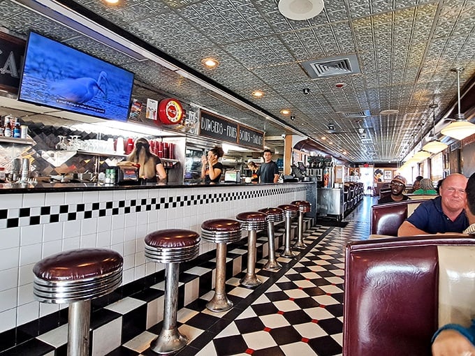 Classic black and white checkered floors meet cherry-red counter stools—this isn't retro cosplay, folks, it's the real nostalgic deal.