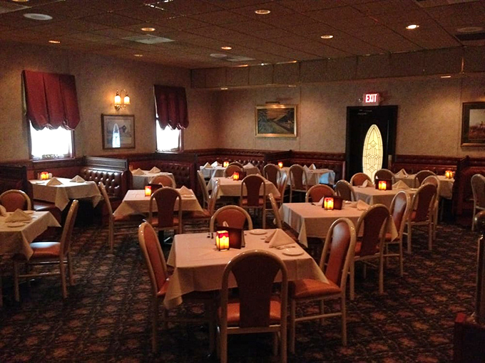 Classic elegance awaits inside with white tablecloths, warm lighting, and burgundy chairs—dining as it should be, without pretension.