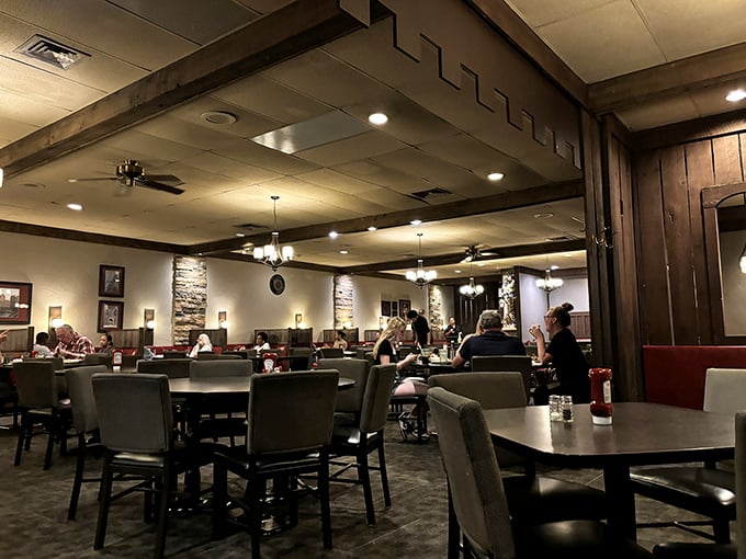 Step into the warm embrace of wood paneling, stone accents, and red booths that whisper, "The 1970s called—they want you to enjoy an excellent steak while you're visiting."