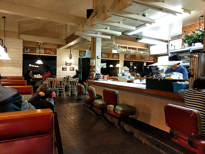 Red vinyl booths and honest lighting create the perfect backdrop for serious comfort food conversations.