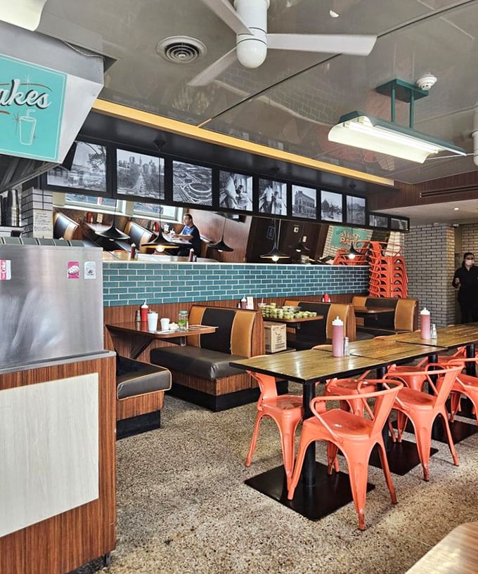 Retro meets modern in this diner paradise where coral chairs and wood-paneled booths create the perfect backdrop for sandwich-induced euphoria.