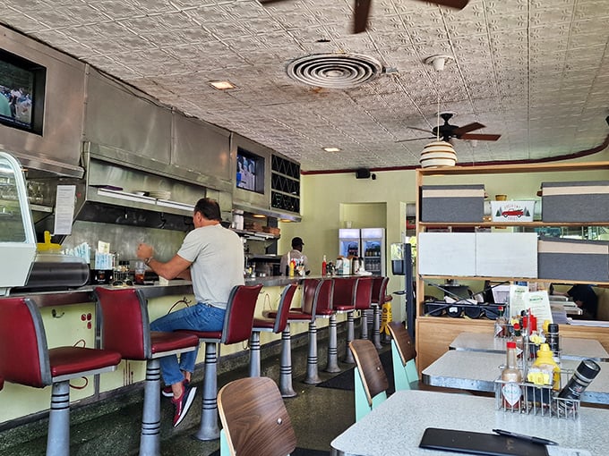 Counter culture at its finest—red vinyl stools, pressed tin ceiling, and the rhythmic dance of short-order cooking that's become a lost art in chain restaurants.