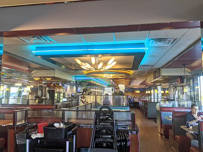 Step inside and the blue neon lighting casts a cool glow across burgundy booths – this isn't just dining, it's time travel with silverware.