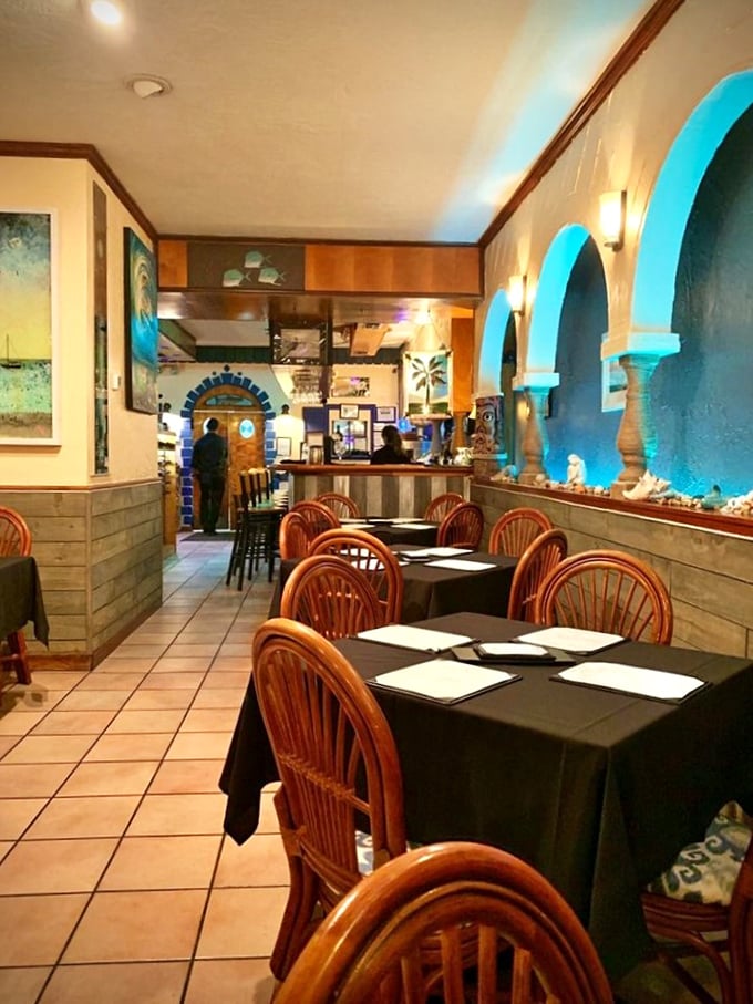 Blue-lit alcoves cast an ethereal glow across the intimate dining space, creating the perfect backdrop for seafood that deserves your full attention.
