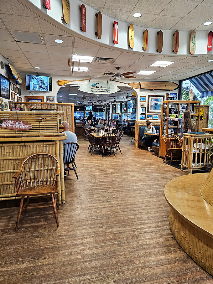 Surfboards line the ceiling like a museum of wave-riding history, while bamboo dividers create cozy nooks for morning feasts and coffee confessions.