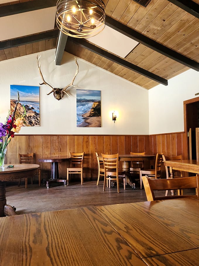 Wooden beams, coastal photography, and mounted antlers create the perfect rustic-chic atmosphere—like your coolest grandparent's cabin got a subtle upgrade.