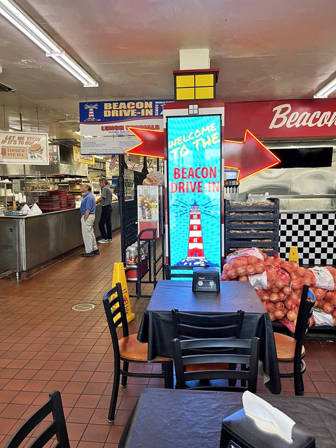 Step inside and the sensory overload begins—neon signs, checkered patterns, and that digital lighthouse beacon promising delicious adventures ahead.