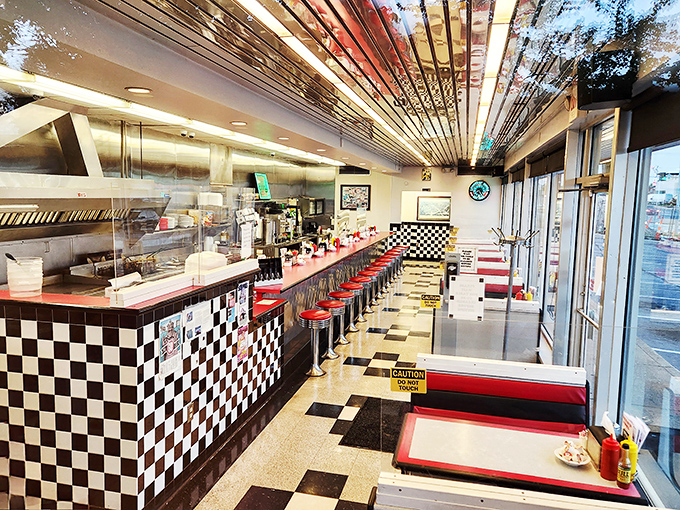 Classic Americana in its purest form—red vinyl stools, checkered counters, and a ceiling that's witnessed decades of late-night confessions and early morning revivals.