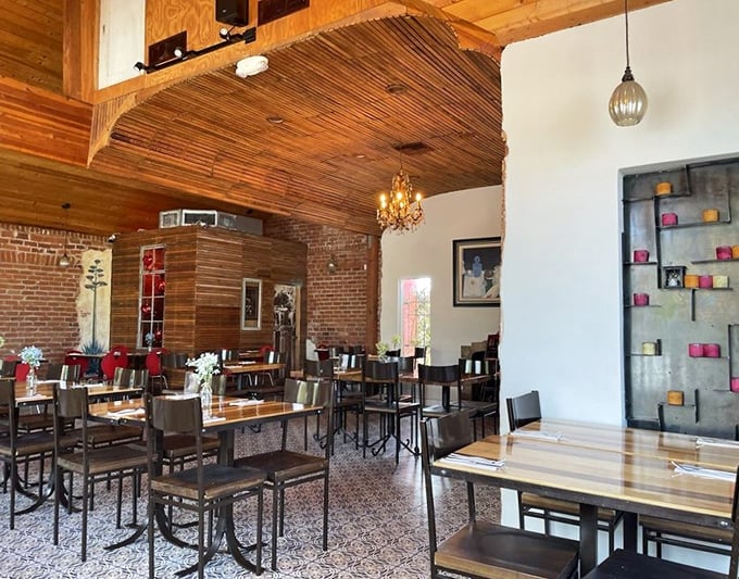 Rustic wooden ceilings meet elegant chandeliers in this thoughtfully designed space where comfort and style dance together like perfect dining companions.