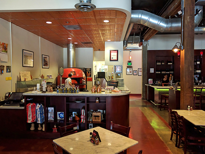 Industrial chic meets Neapolitan warmth. The wood-fired oven isn't just equipment—it's the beating heart of this pizza sanctuary.