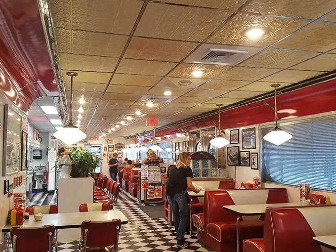 Step inside and the 1950s never ended—checkerboard floors, cherry-red vinyl booths, and pendant lights creating the perfect backdrop for comfort food conversations.