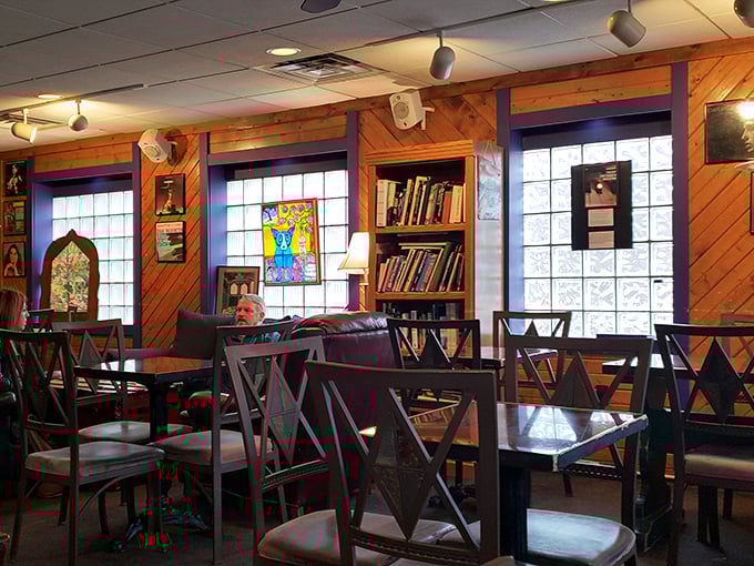 Wooden paneling meets purple accents in this cozy sanctuary where books and conversations flow as freely as the espresso.