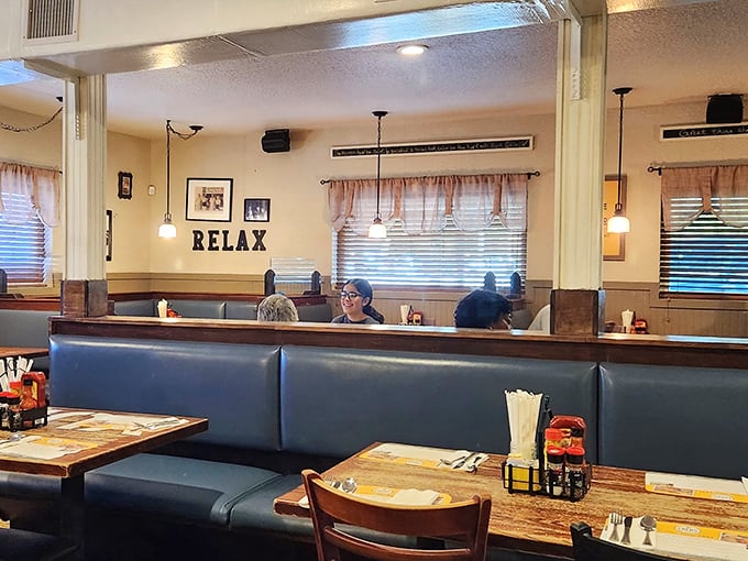 The "RELAX" sign isn't just decoration—it's a command you'll happily obey once settled into these cozy blue booths with a plate of Southern goodness.