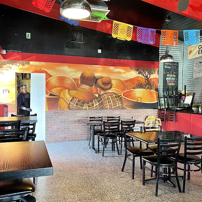 Colorful papel picado banners dance overhead while the mural tells the story of tradition. This isn't décor—it's a family history painted in copper and flame.
