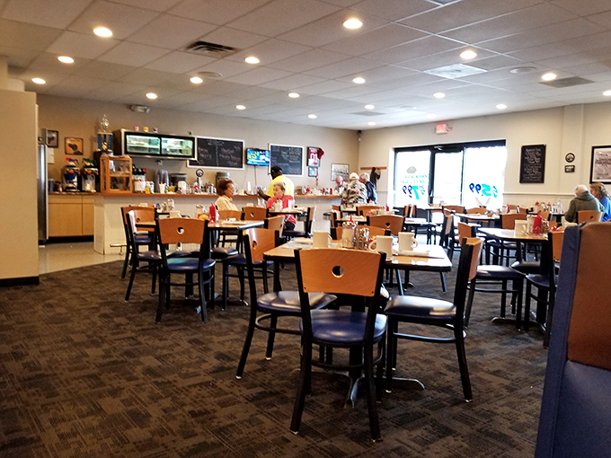 Classic diner geometry: wooden chairs, blue seats, and tables arranged for maximum conversation potential. The kind of place where strangers become friends over coffee refills.