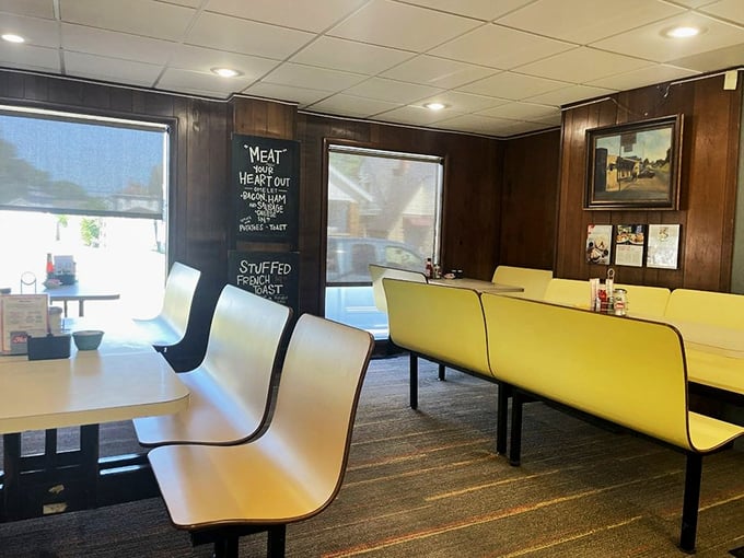 Classic yellow booth seating and wood-paneled walls – dining here is like time traveling to when conversation trumped Instagram posts.