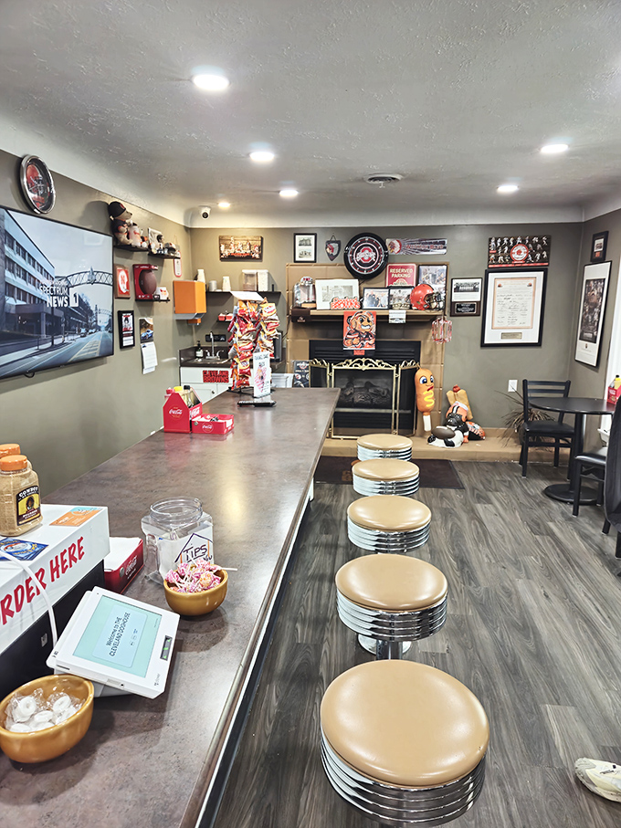 Classic diner counter seating invites you to belly up for a front-row view of hot dog artistry. Cleveland sports memorabilia creates the perfect backdrop.