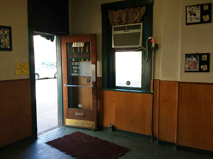 Step inside and time stands still – wood paneling, simple furnishings, and sports memorabilia tell you this place prioritizes pizza perfection over trendy décor.