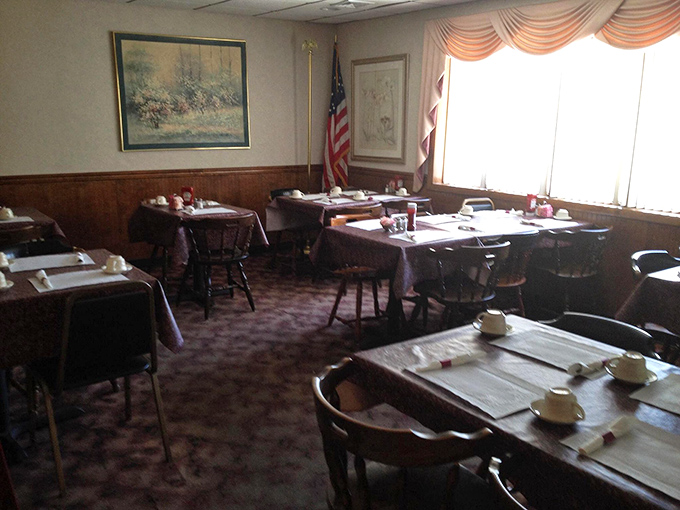 Step inside to a dining room where time slows down – wood paneling, tablecloths, and an American flag create that perfect small-town restaurant ambiance.