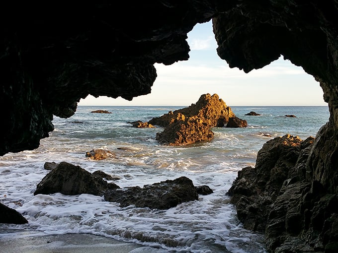 Nature's perfect picture frame! Peer through this sea cave opening and discover why photographers flock here like seagulls to a forgotten sandwich.