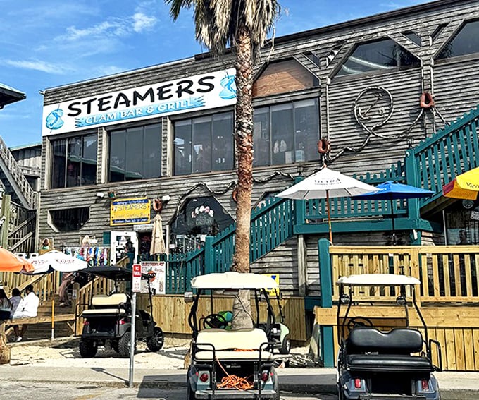 Steamers Clam Bar & Grill embodies Old Florida charm with its weathered wood exterior and inviting deck—golf carts included, because who needs a Ferrari here?