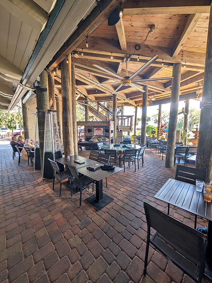 Rustic wooden beams meet modern comfort in this open-air dining space. The brick pavers below add earthiness to every elevated bite.