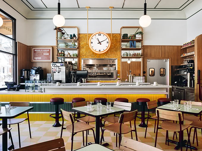 Mid-century modern meets contemporary cool inside, where the checkerboard floor and warm wood tones create a space that's both nostalgic and fresh.