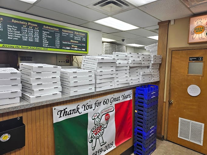 Pizza boxes stacked high like a carbohydrate skyscraper – a beautiful sight that signals you're about to experience something truly special.