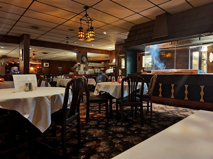 Classic supper club ambiance in full effect—white tablecloths, warm wood tones, and lighting dim enough to make everyone look like they've made excellent life choices.