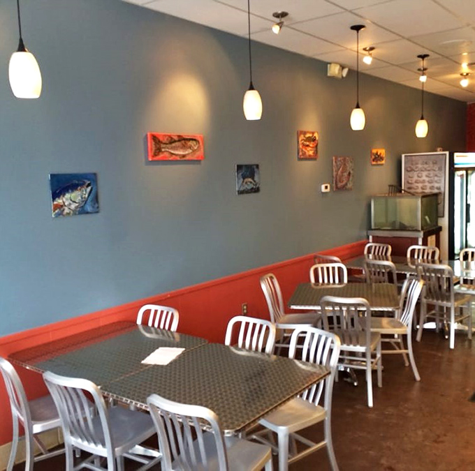 Simple metal tables, fish-themed art, and zero pretension. This dining room isn't trying to impress you—until the food arrives and does exactly that.