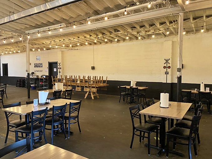 Industrial chic meets barbecue comfort in this spacious dining room where the only thing more inviting than the string lights is the promise of what's coming from the kitchen.