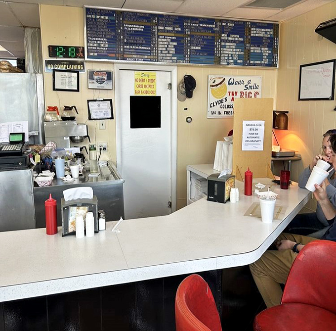 Behind this counter, burger magic happens daily. The "No Complaining" sign says it all—who could possibly complain when paradise comes on a bun?