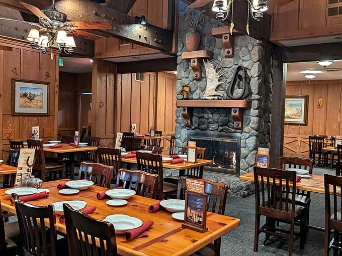 Wooden beams, stone fireplace, and tables set for feasting. This isn't just dining—it's a warm embrace in ranch-style comfort.