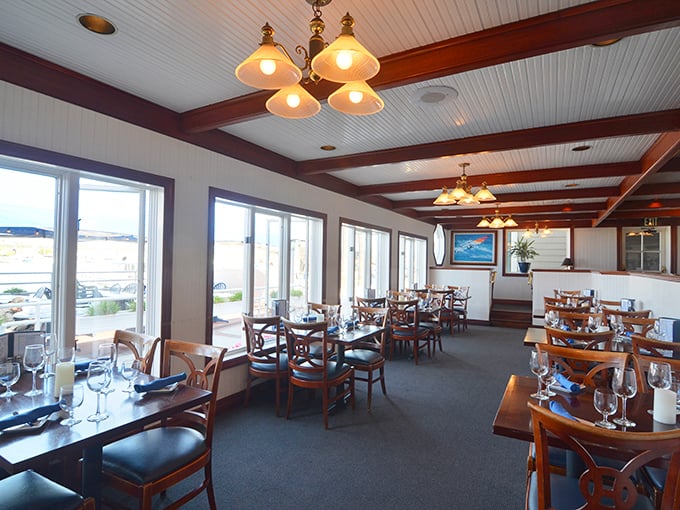 Exposed wooden beams, classic pendant lighting, and panoramic harbor views create the perfect backdrop for seafood indulgence at Newport Landing.