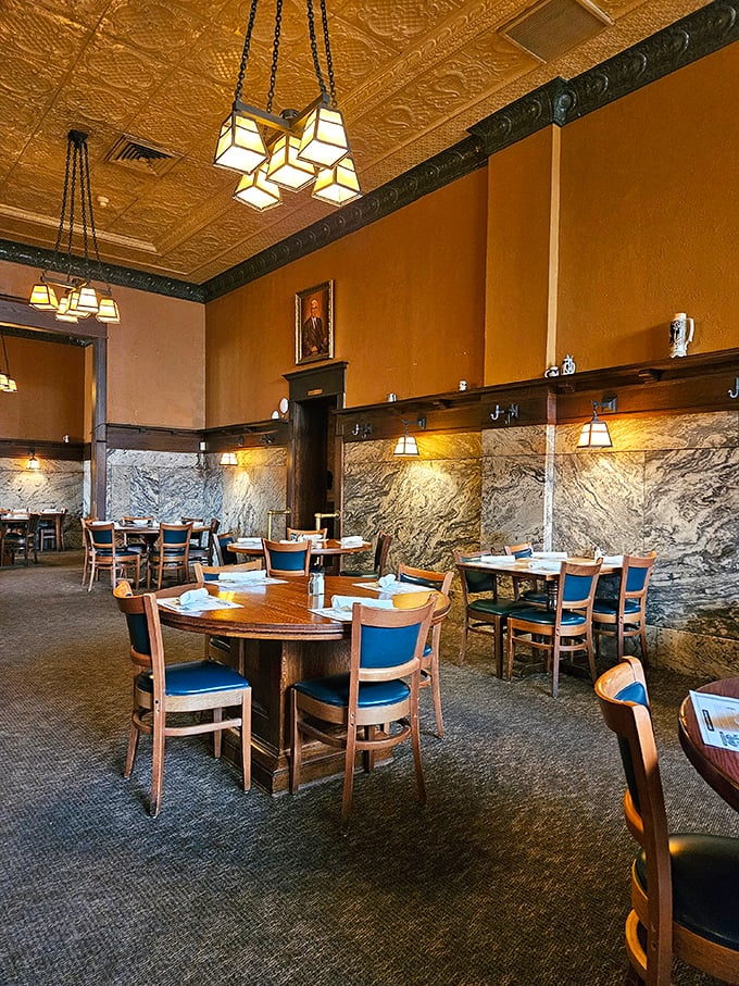 Step inside and time slows down—marble wainscoting meets warm walls under ornate tin ceilings, while blue chairs await diners seeking a taste of Ohio's culinary history. 