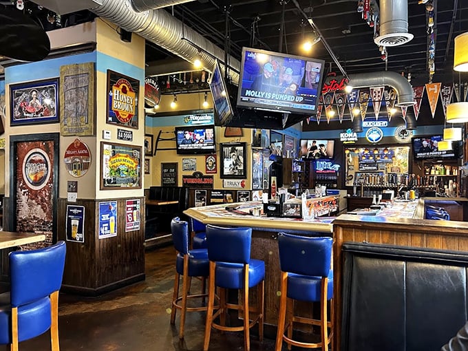 Step inside and the sports bar meets culinary playground vibe hits you immediately—blue bar stools, exposed ductwork, and enough TVs to satisfy even the most dedicated sports fan.