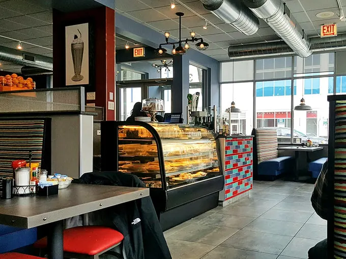 Inside, industrial chic meets comfort with exposed ductwork, colorful tile accents, and a pastry case that whispers sweet nothings to your willpower.