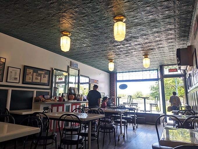 Tin ceilings, simple lighting, and no-nonsense tables create the perfect stage where the real stars—those magnificent burgers—can shine without distraction.