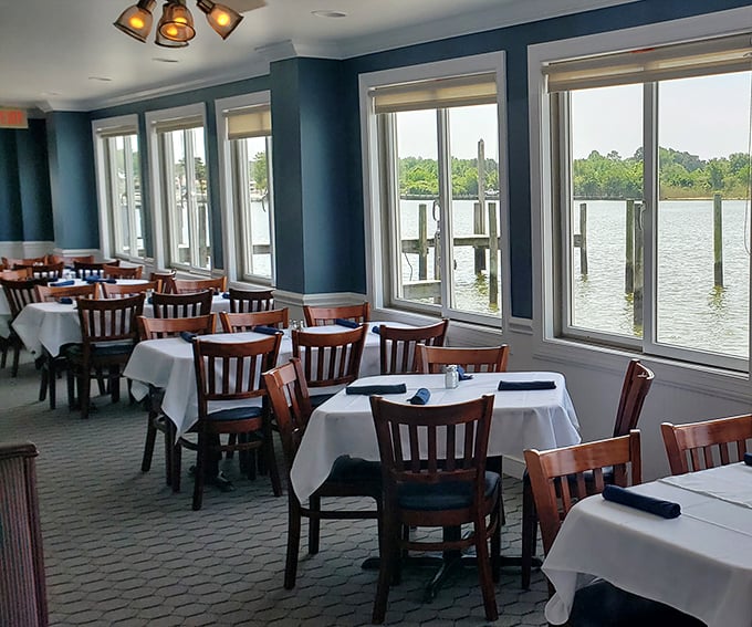 Blue walls frame postcard-perfect water views, creating the ideal backdrop for the main event—those legendary crab cakes everyone drives hours to devour.