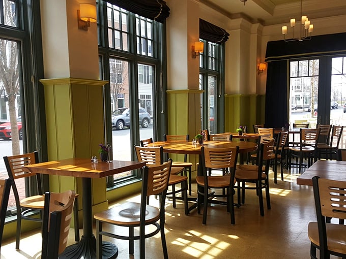 Sunlight streams through towering windows, casting golden patterns across wooden tables where memorable meals and conversations unfold.