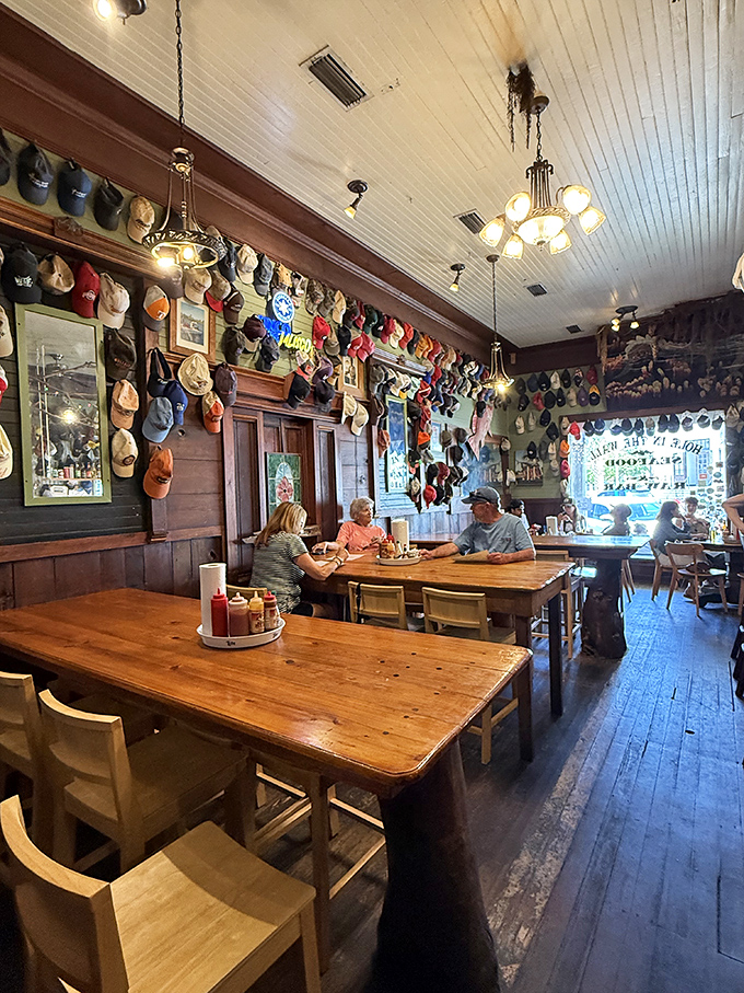 Baseball caps line the walls like trophies of adventures past, while wooden tables bear the honorable scars of countless seafood feasts. This isn't décor—it's a visual guestbook.