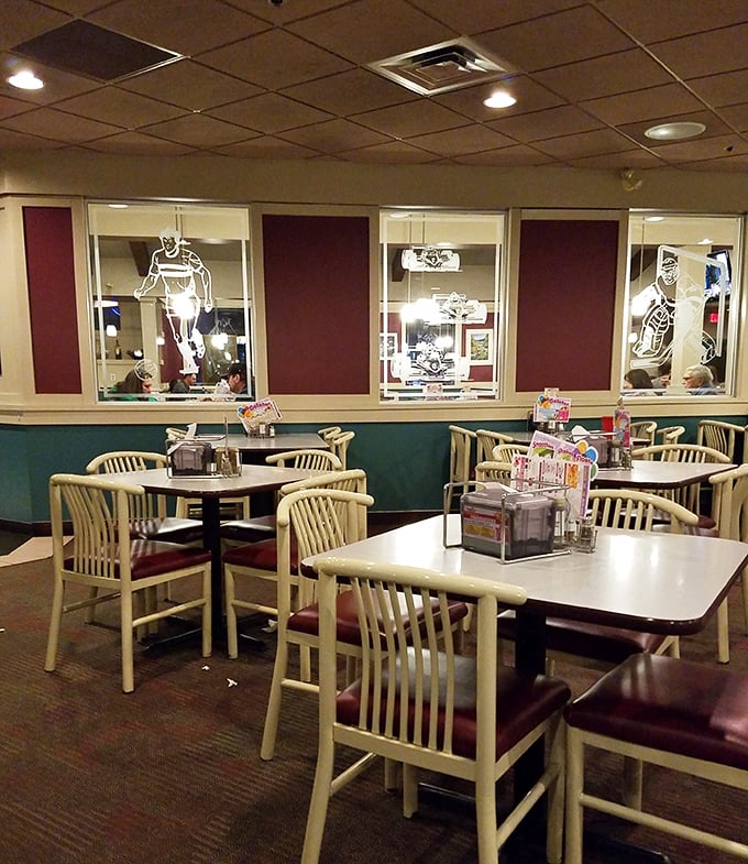 Classic pizzeria charm with those cream chairs and burgundy accents. The sports silhouettes in the dividers remind you you're in a place where memories are made.