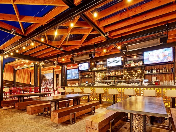Exposed wooden beams and industrial-chic design create a space that feels like the world's coolest barn, if barns served life-changing fried chicken and craft cocktails.